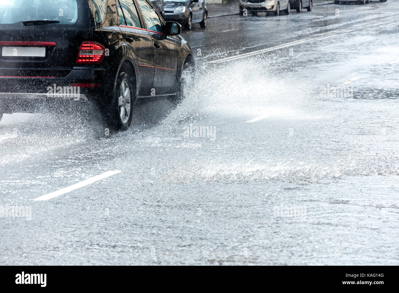 rainwater splashing from car wheels during heavy rain Stock Photo - Alamy