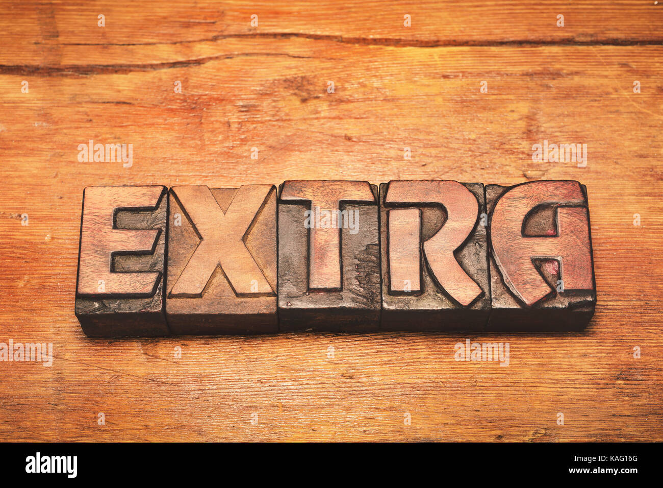 extra word made from vintage letterpress blocks on wooden surface Stock ...