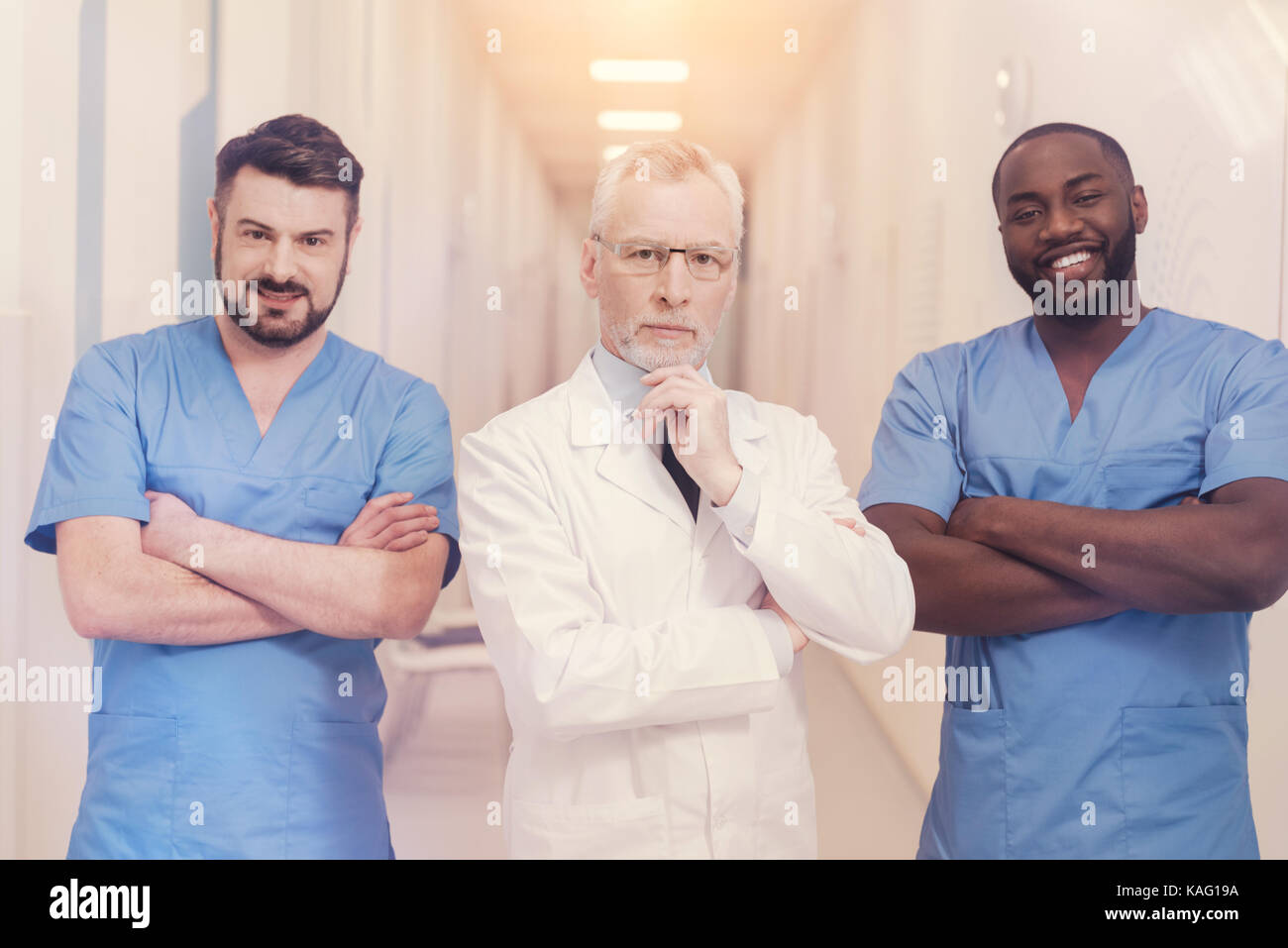 Serious professor standing between two medical students Stock Photo - Alamy