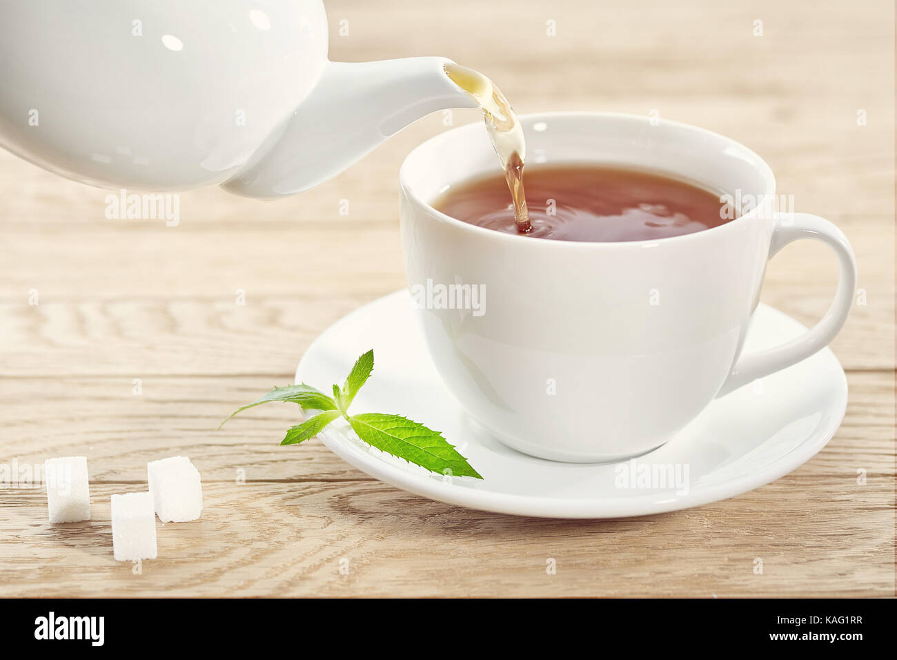 cup with green tea, sugar and teapot on light wooden table background ...