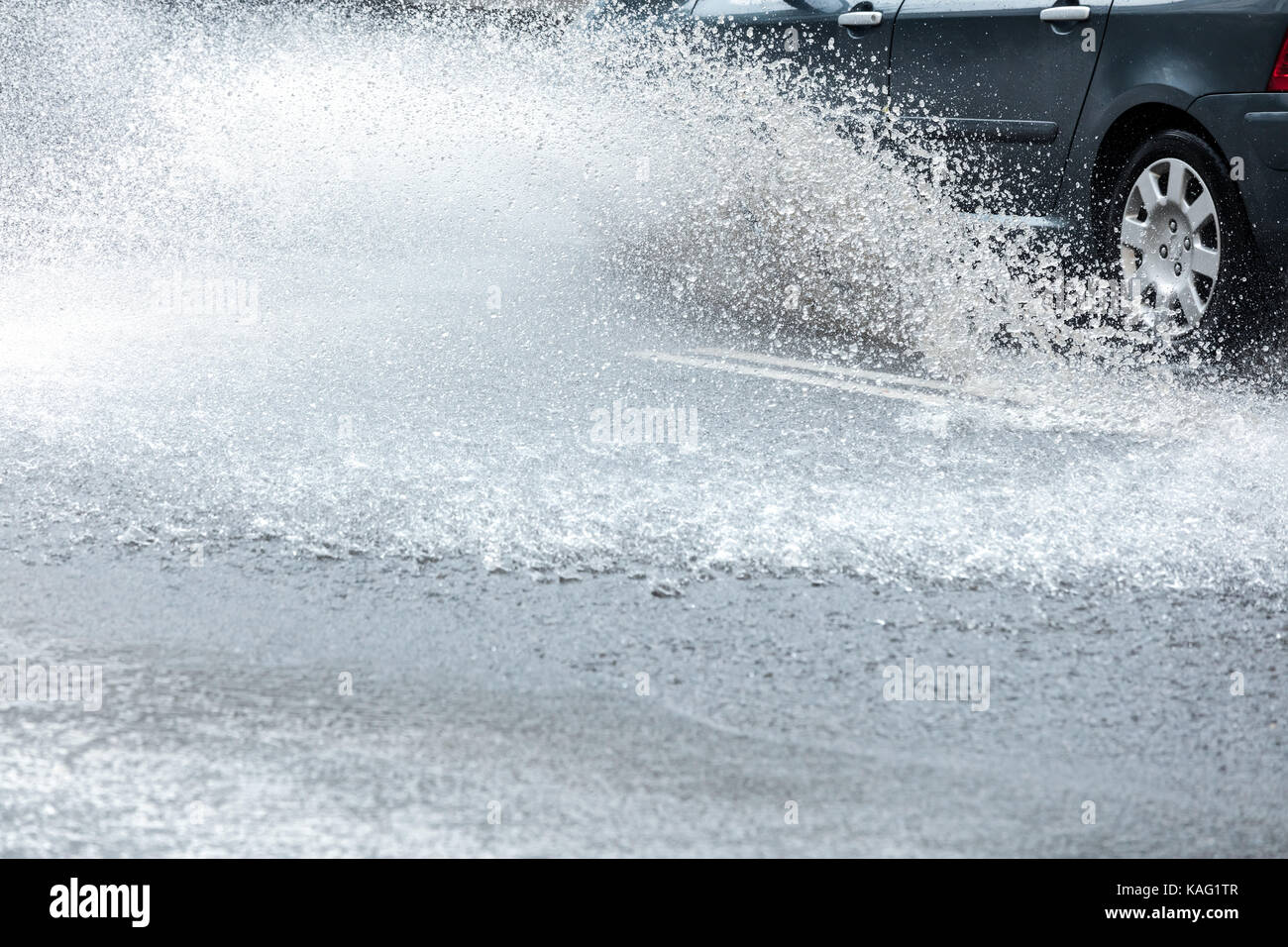 city road flooded with rainwater. splashing car on wet street Stock ...