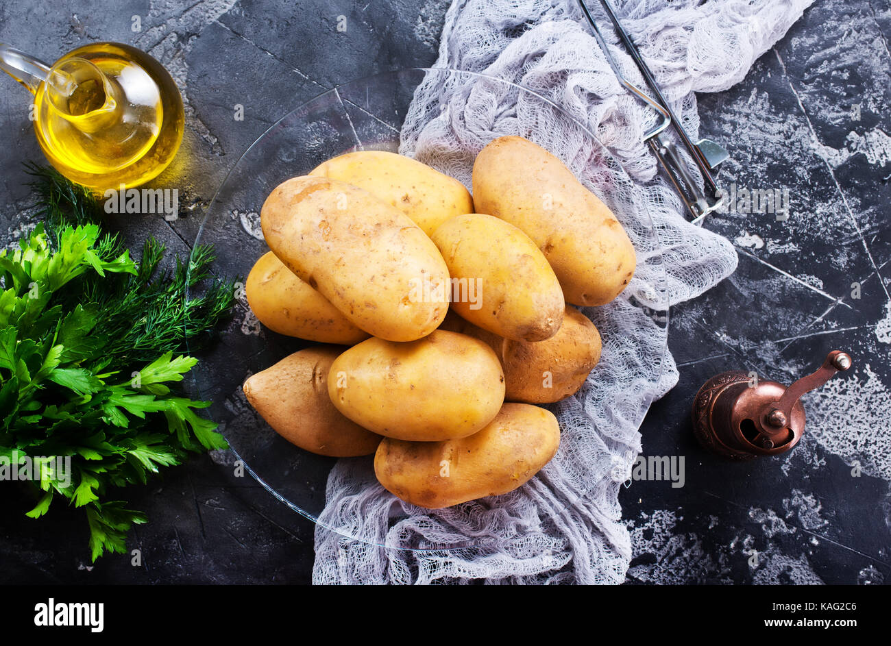 raw potato on plate and on a table Stock Photo - Alamy