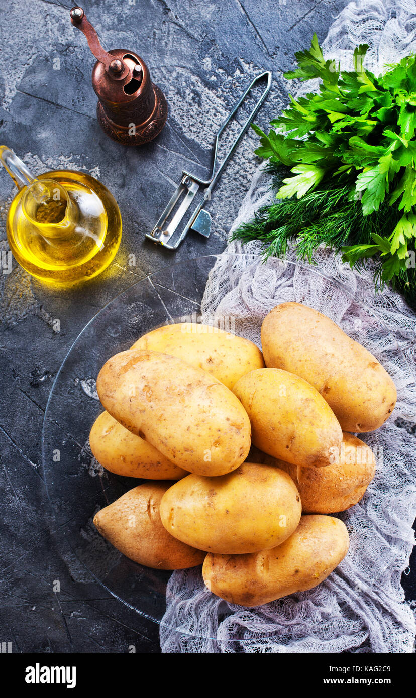 raw potato on plate and on a table Stock Photo - Alamy