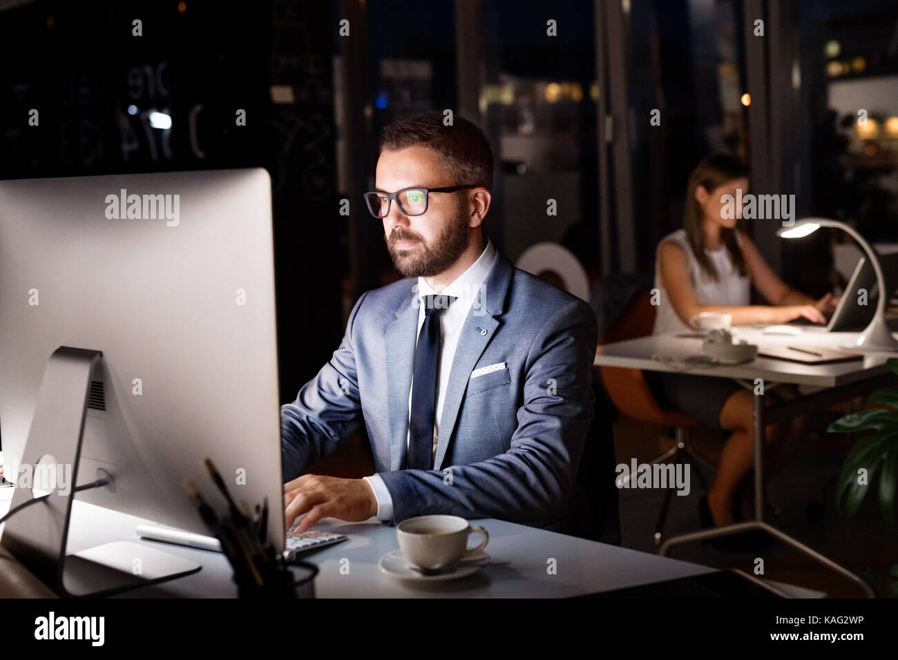 Businessman in his office at night working late Stock Photo - Alamy