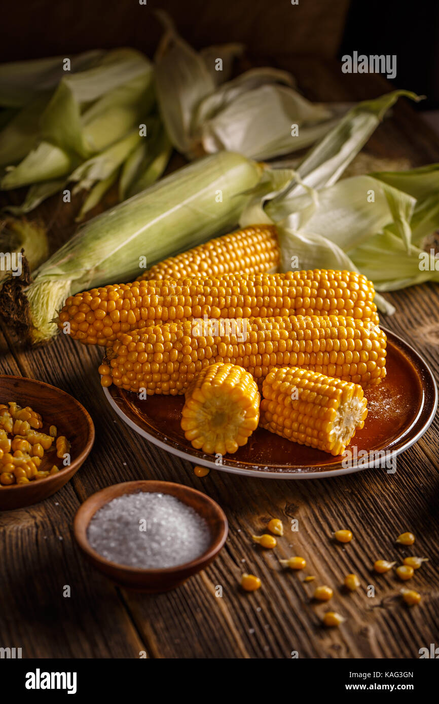 Boiled corn with salt on rustic style background Stock Photo - Alamy