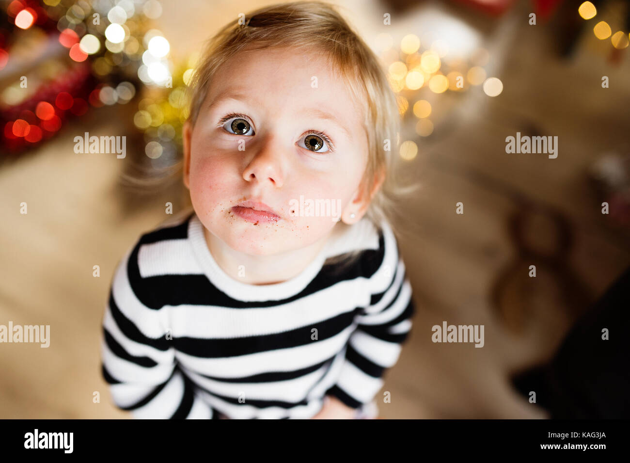 Cute little girl in striped dress, crumbs around her mouth Stock Photo ...