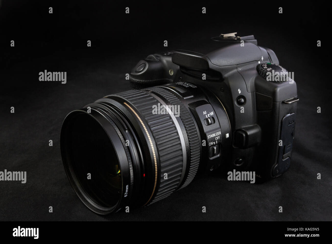 One black DSLR camera isolated on black background with fitted zoom ...