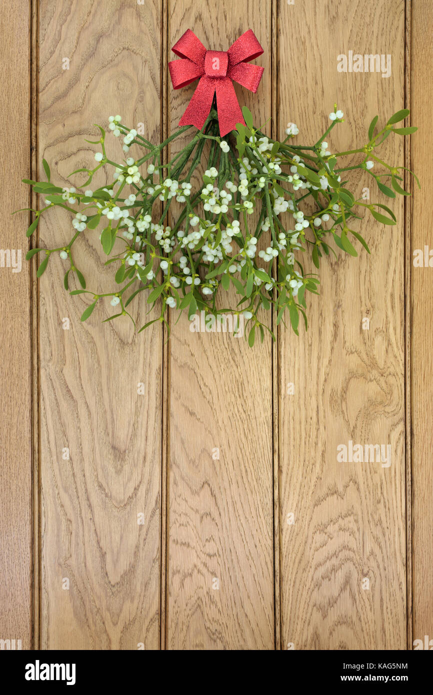 Christmas mistletoe bunch with red bow on oak wood background Stock ...