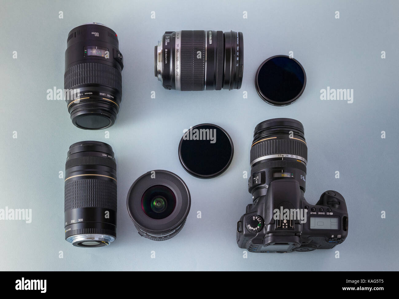 Camera and collection of camera lenses and filters on blue background ...