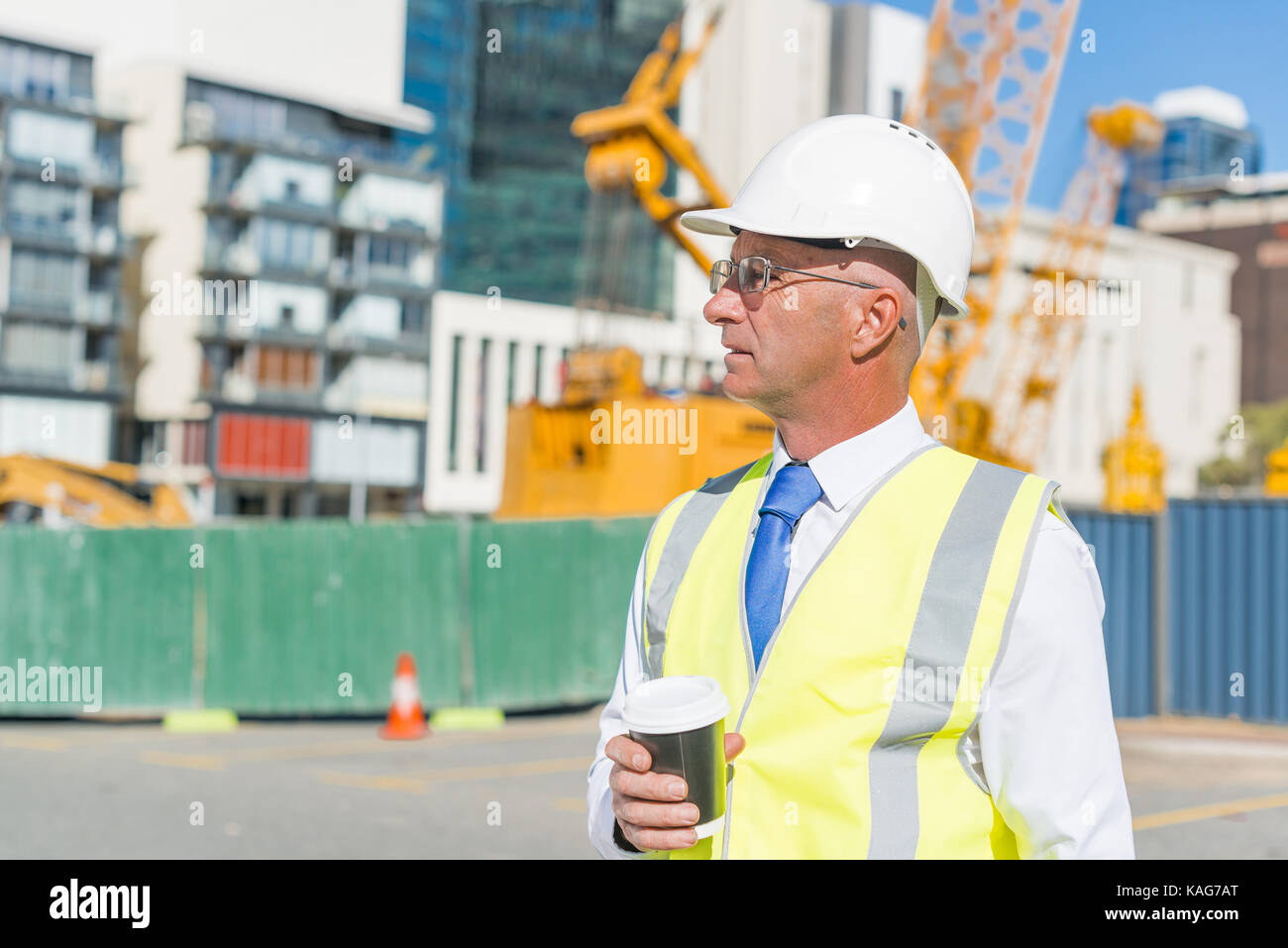 Engineer builder on construction site at sunny day with coffee in hand Stock Photo - Alamy
