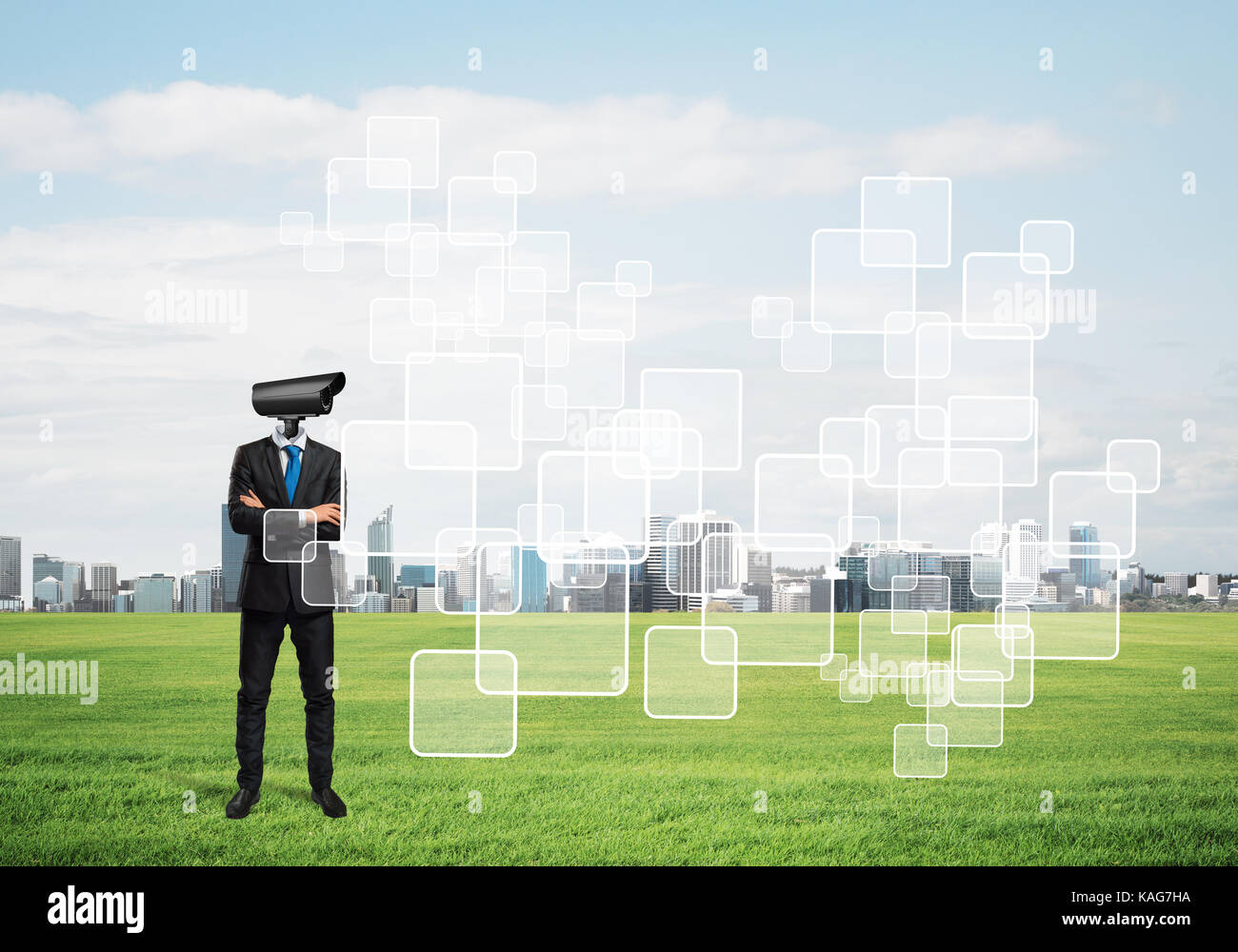 Camera headed man standing on green grass against modern cityscape ...