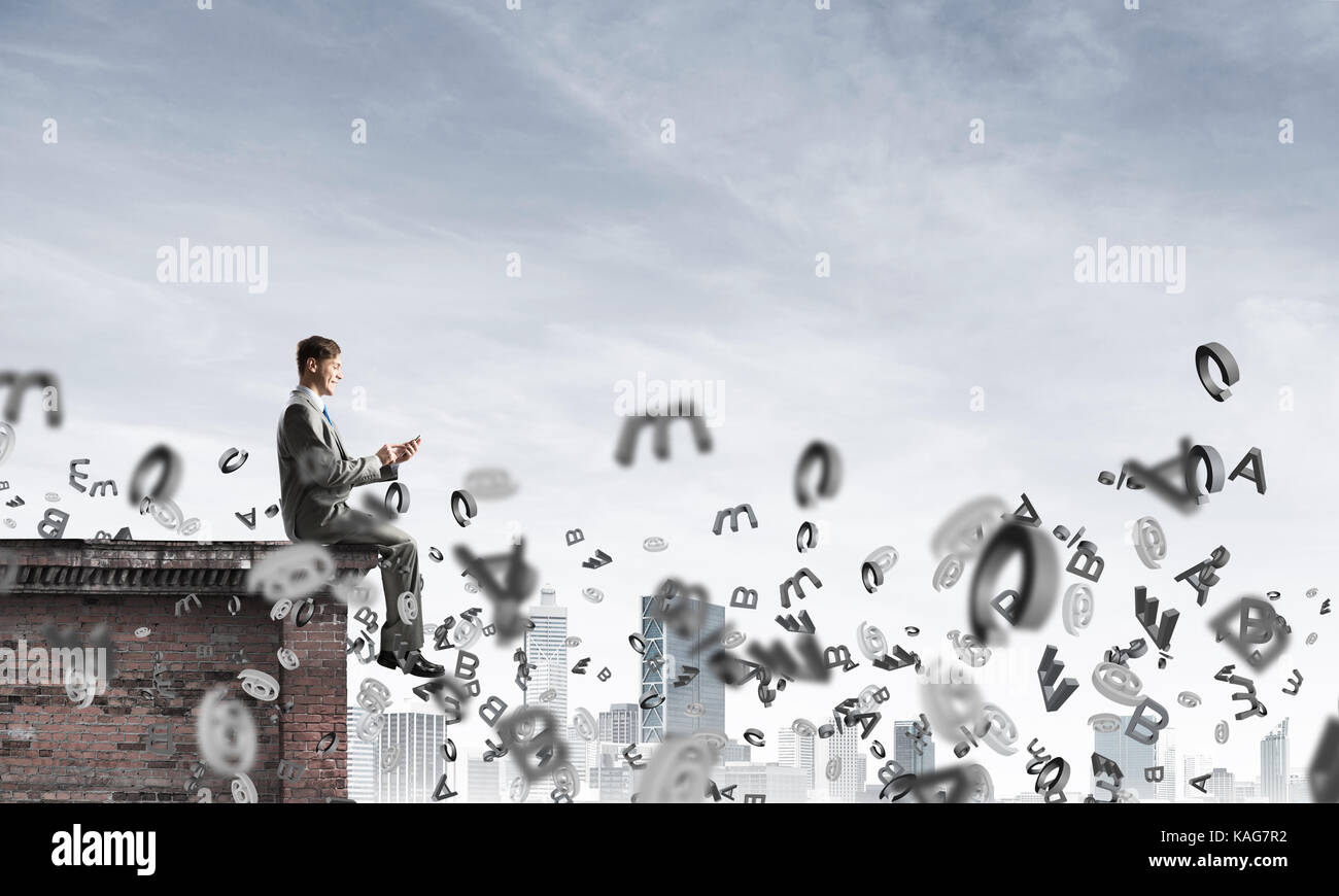 Man on roof edge send message with smartphone and symbols flying around ...