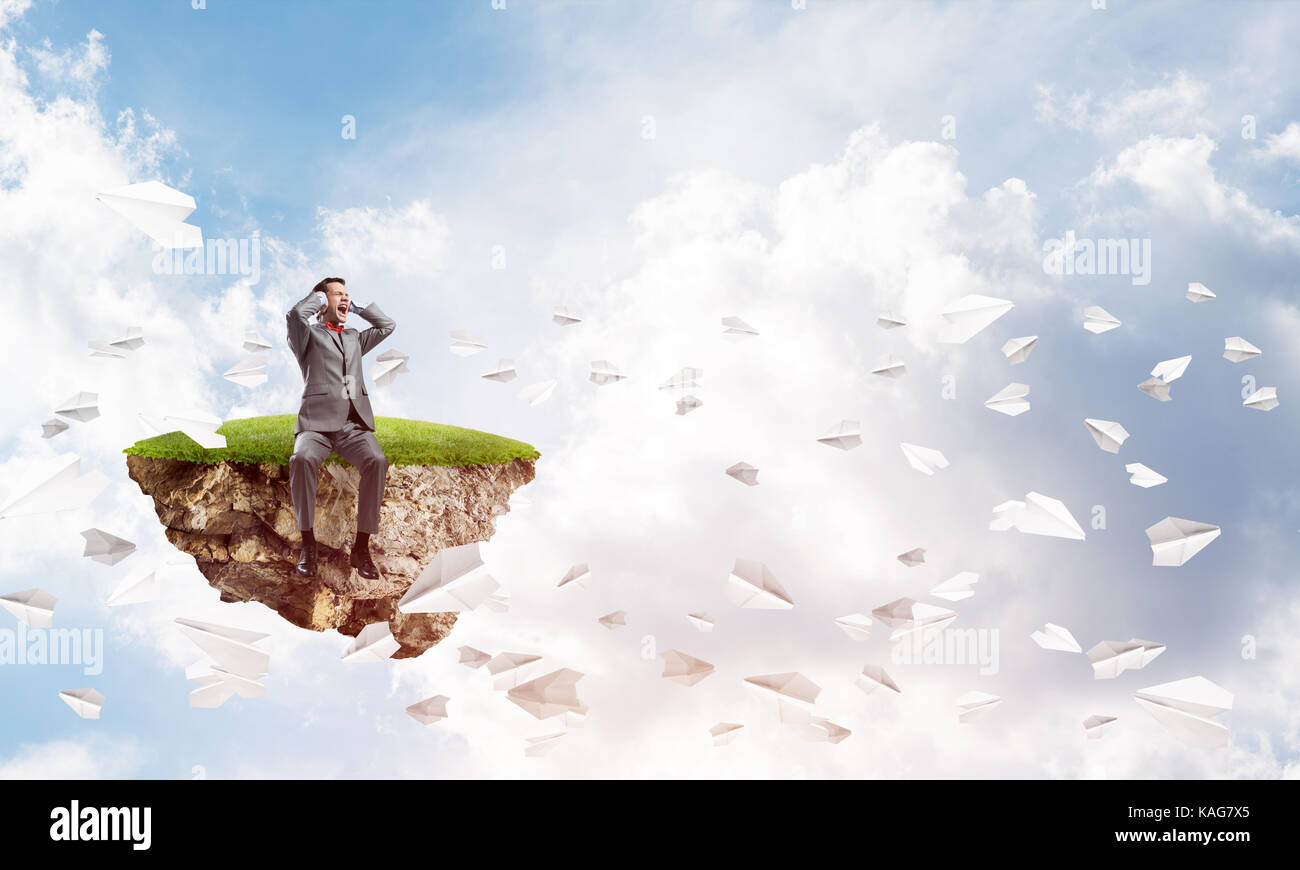 Young man in sky dont want to hear anything and paper planes fly around ...