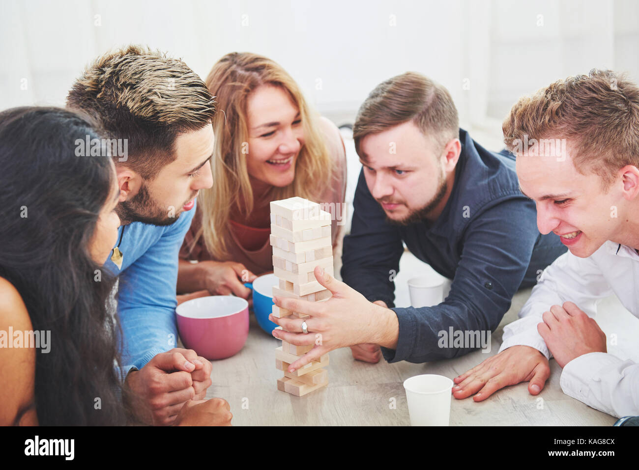 Group of creative friends sitting at wooden table. People having fun ...