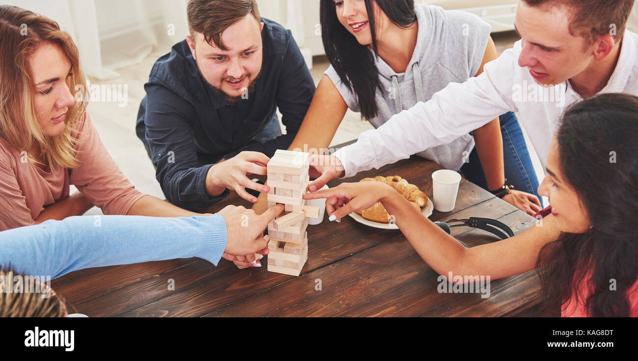 Group of creative friends sitting at wooden table. People having fun ...