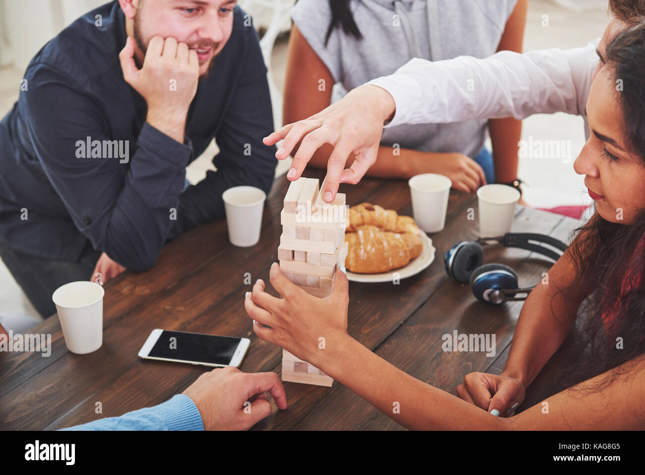 Group of creative friends sitting at wooden table. People having fun ...