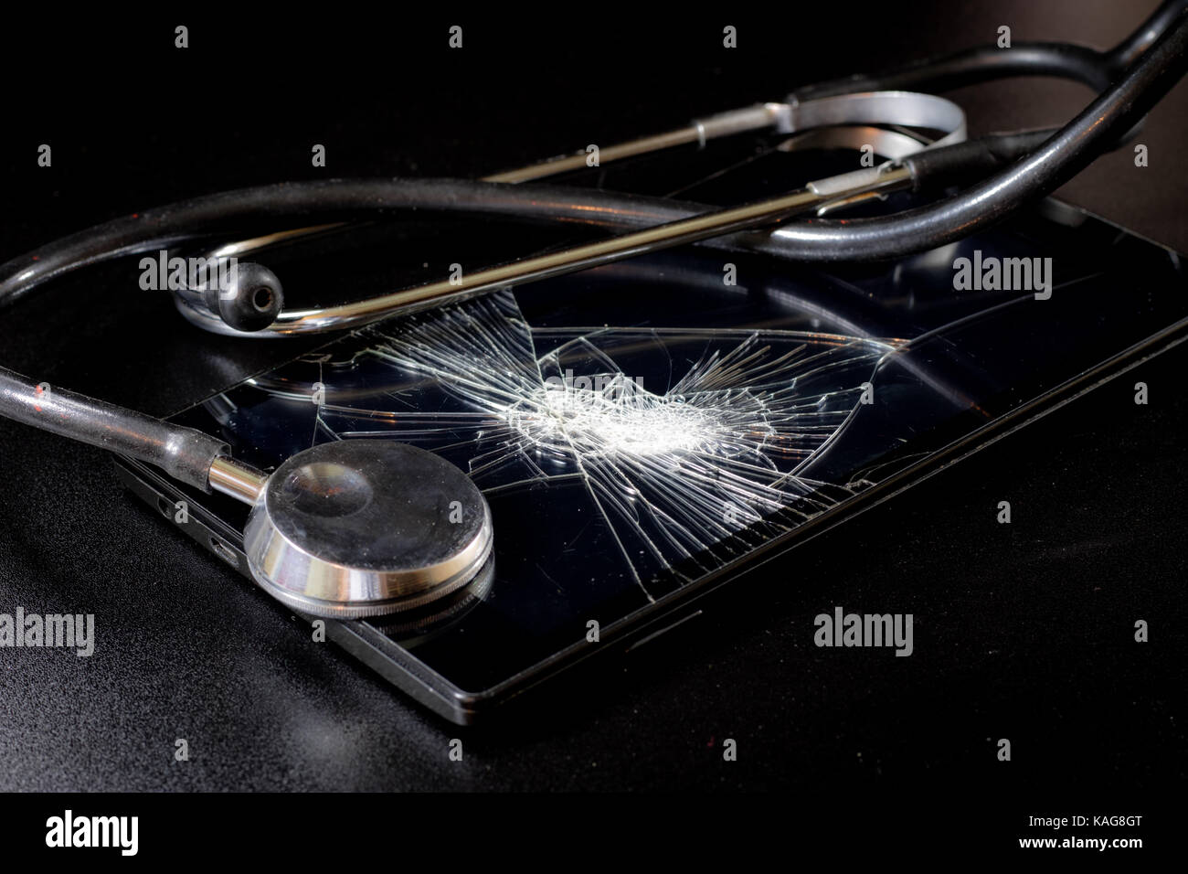 Broken tablet with broken screen and stethoscope in repair. Black table ...