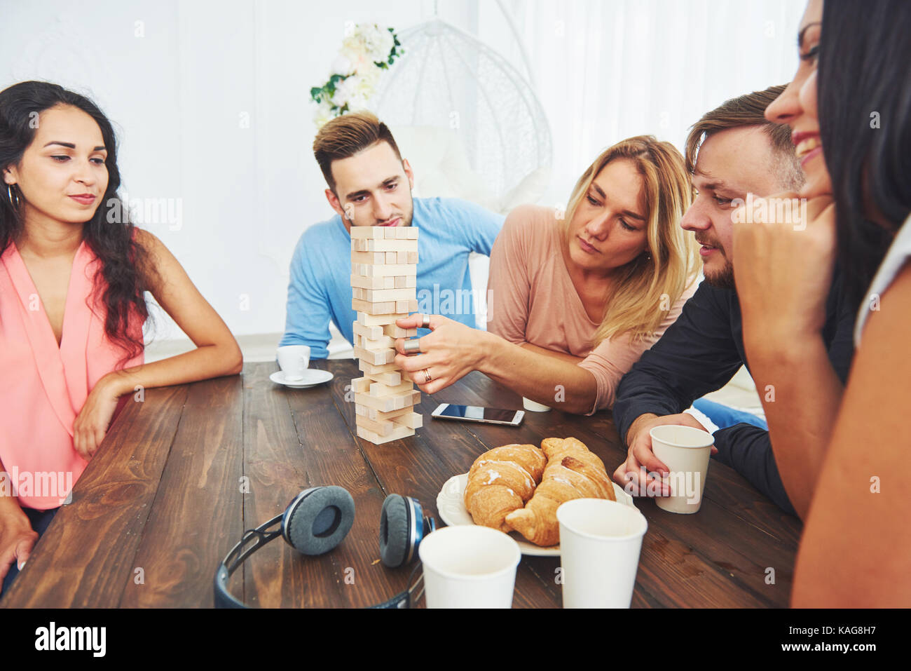 Group of creative friends sitting at wooden table. People having fun ...