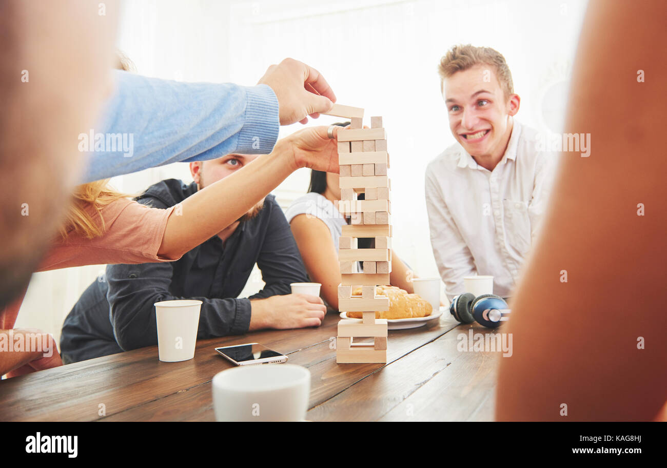 Group of creative friends sitting at wooden table. People having fun ...