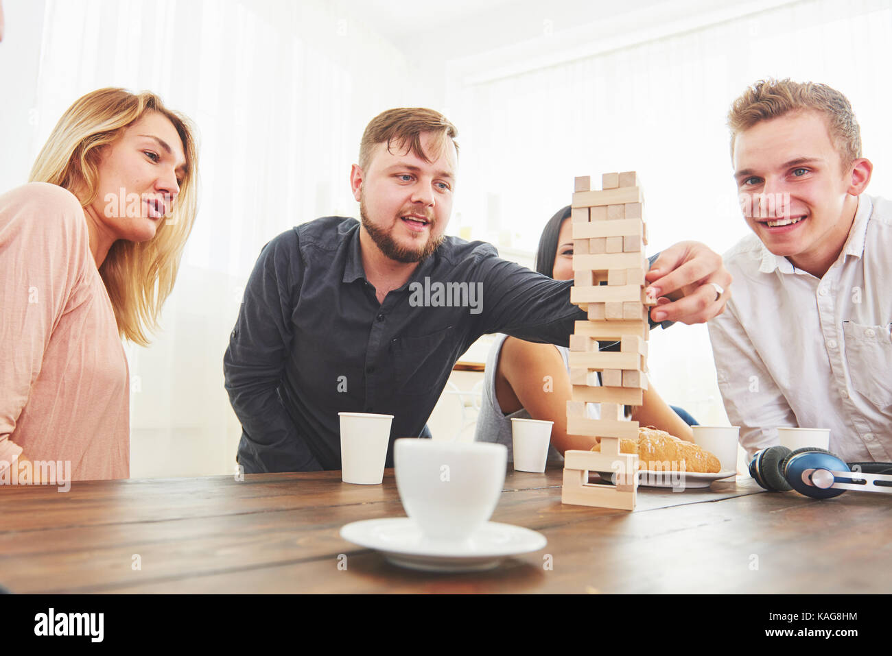 Group of creative friends sitting at wooden table. People having fun ...