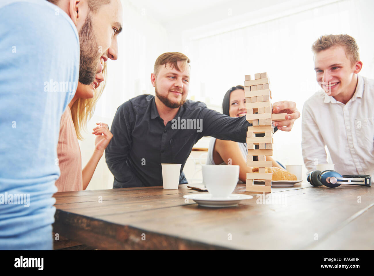 Group of creative friends sitting at wooden table. People having fun ...