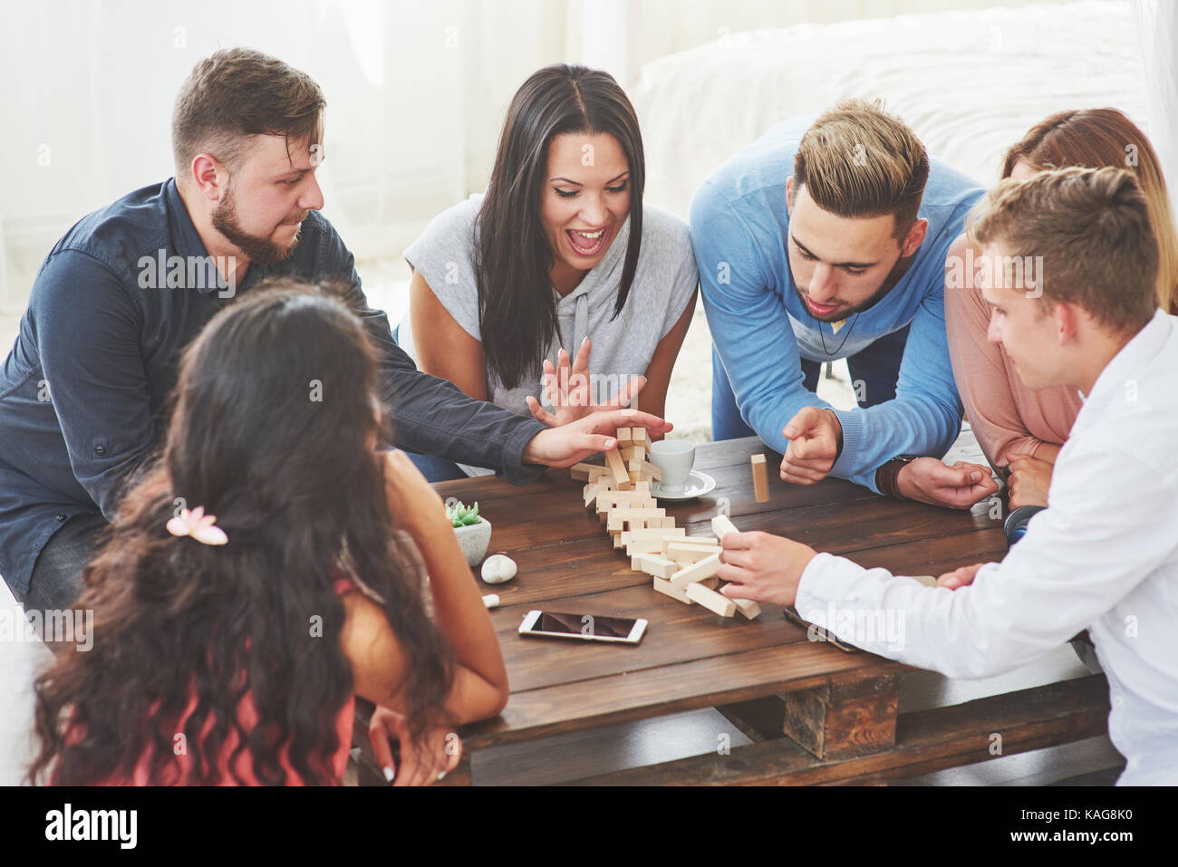 Group of creative friends sitting at wooden table. People having fun ...