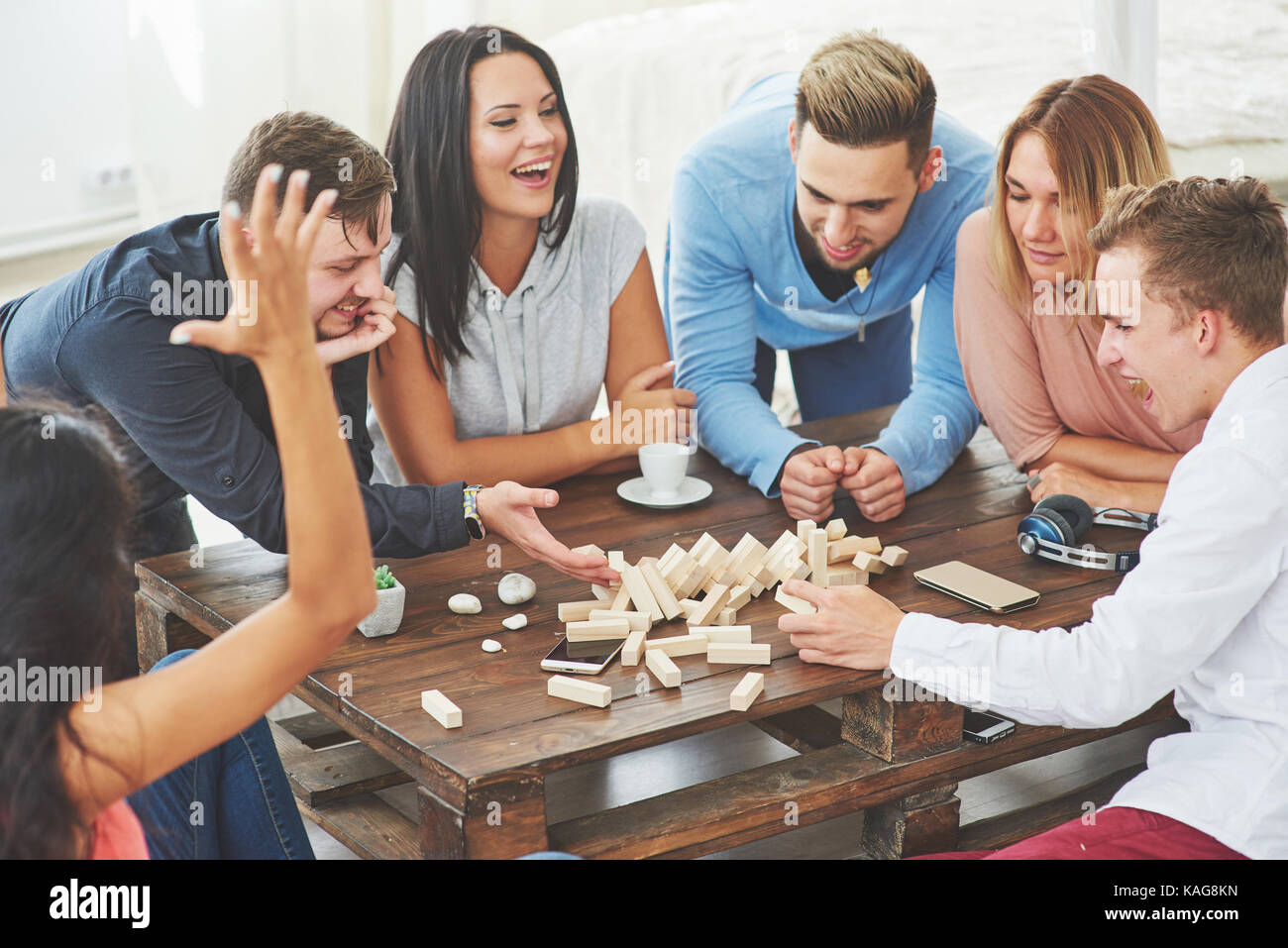 Group of creative friends sitting at wooden table. People having fun ...
