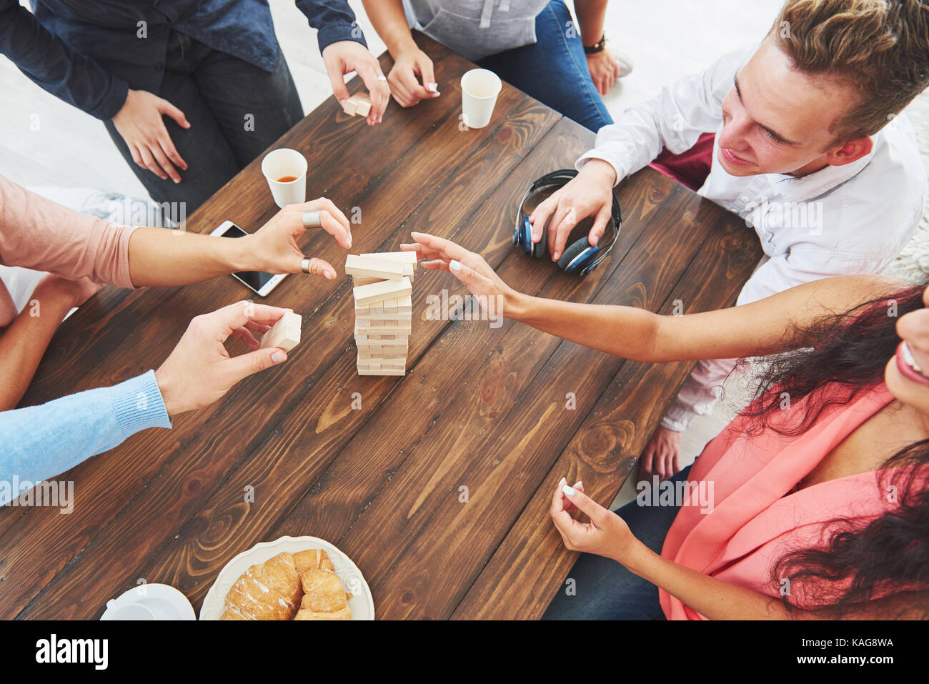 Top view creative photo of friends sitting at wooden table. Friends ...
