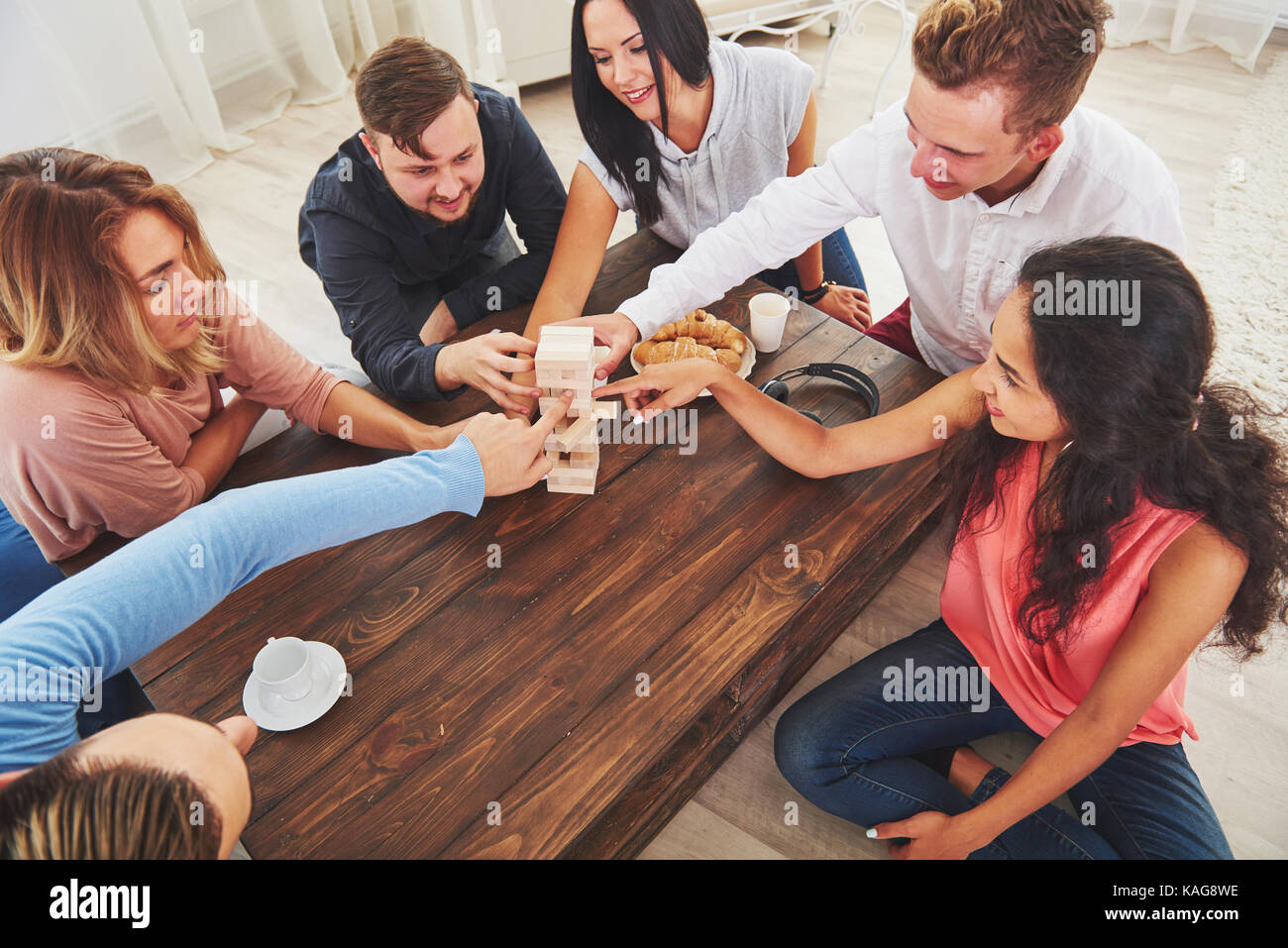 Top view creative photo of friends sitting at wooden table. Friends ...