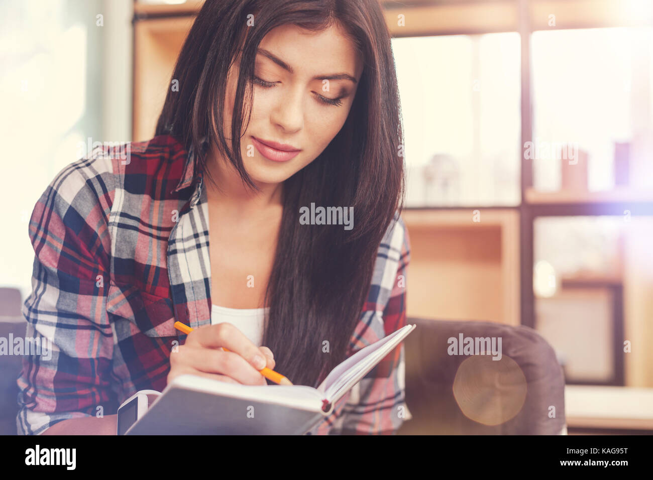 Beautiful young lady writing down ideas in notebook Stock Photo - Alamy