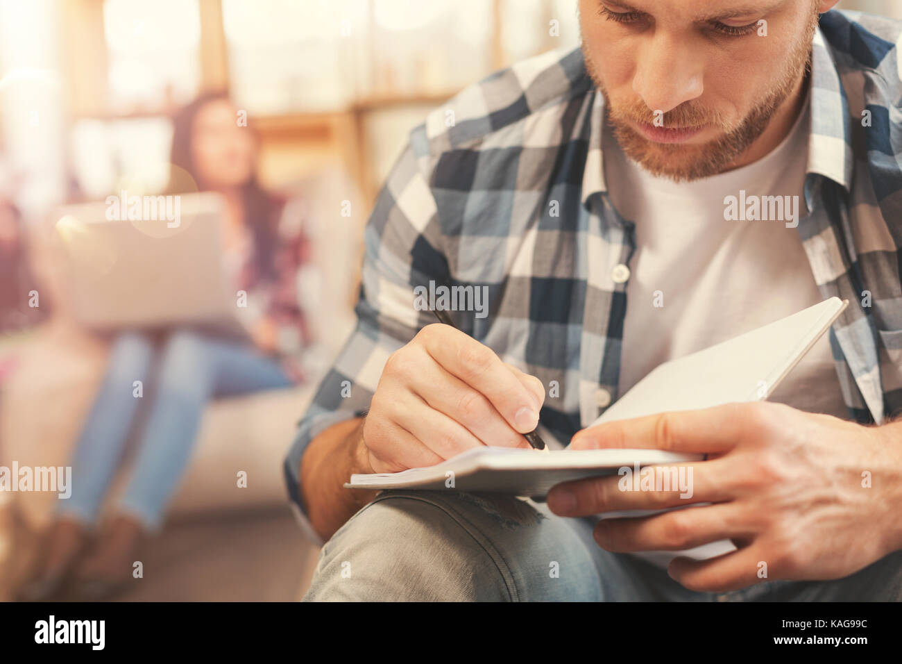 Scaled up look on serious guy making notes Stock Photo - Alamy