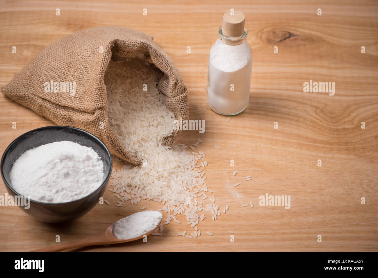 Jasmine white rice in sack and rice flour on wooden table Stock Photo ...