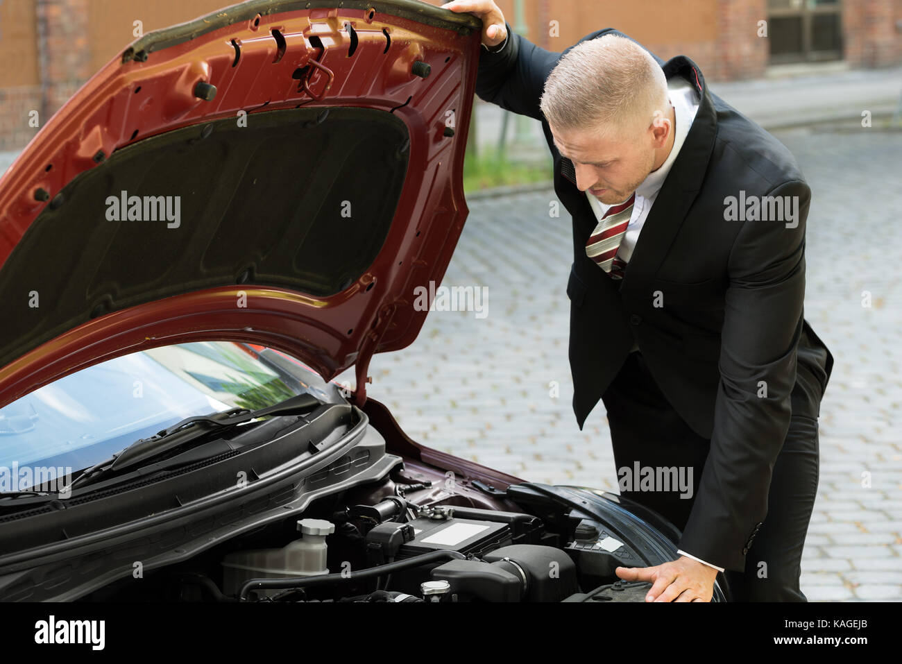 Young Man Looking Under The Hood Of Breakdown Car Stock Photo - Alamy