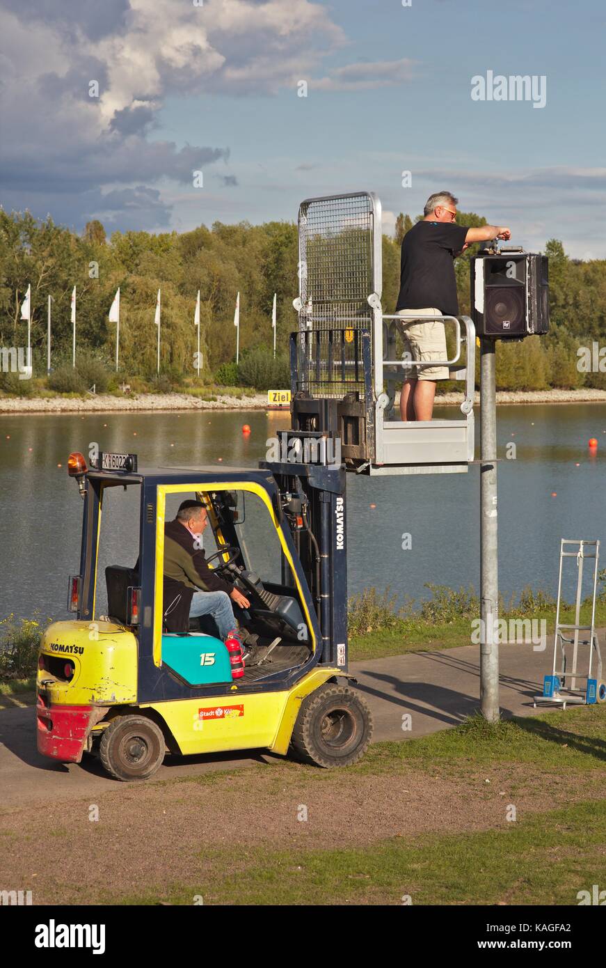 Man standing on forklift dismounting loudspeakers Stock Photo - Alamy