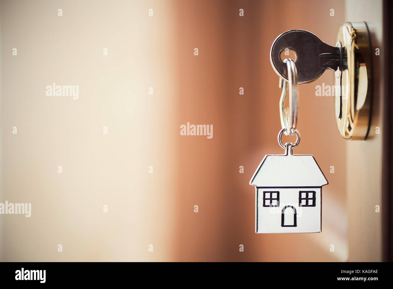 House key on a house shaped silver keyring in the lock of a door Stock ...