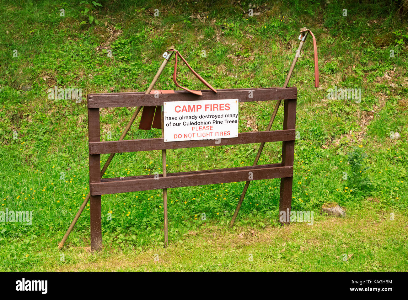 Fire beaters in rack with camp fire warning sign Stock Photo - Alamy