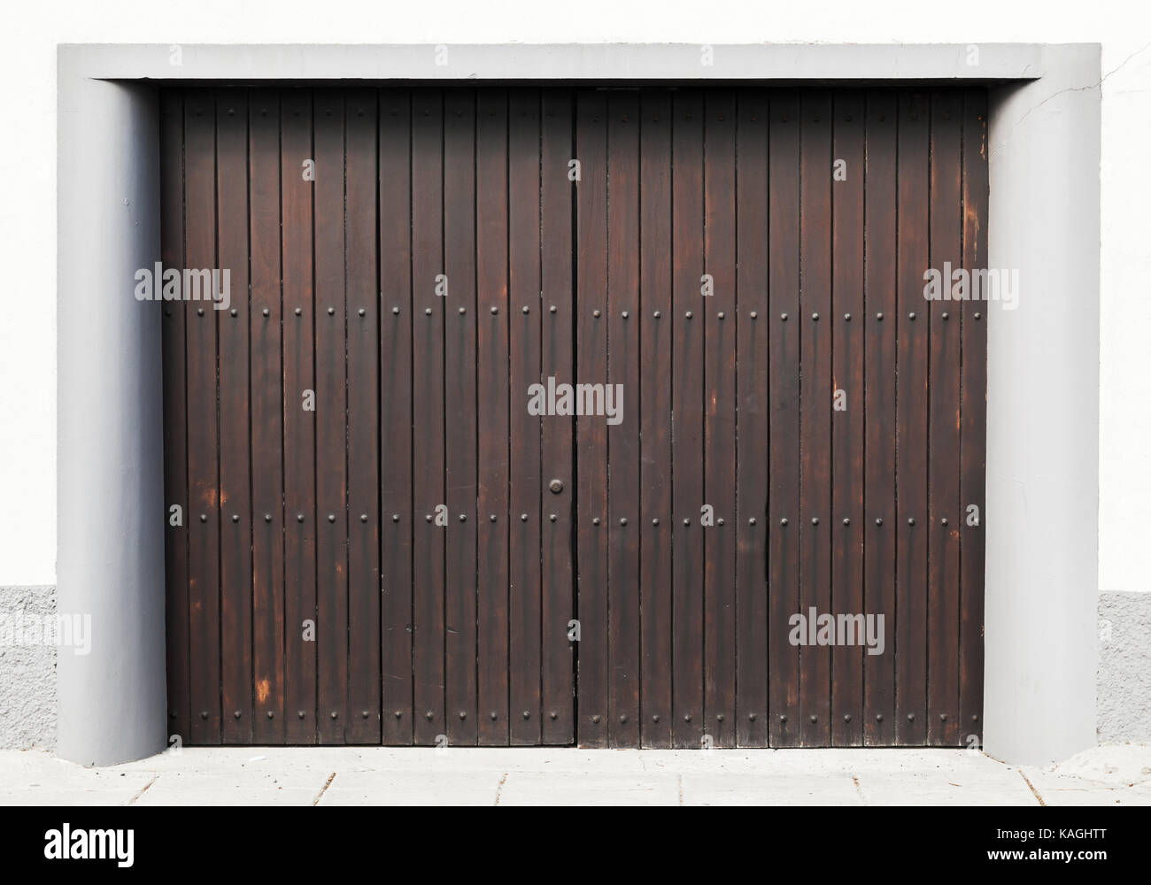 Brown wooden gate in white concrete wall. Background photo texture ...