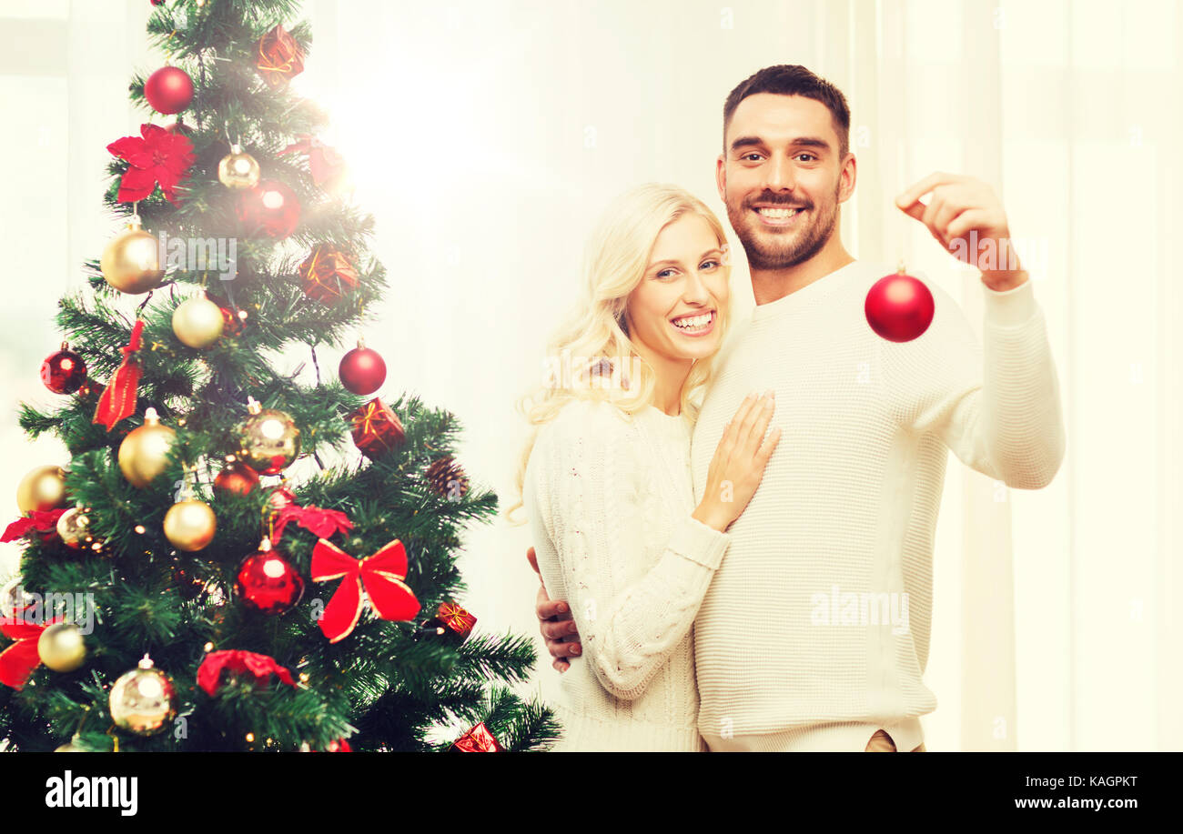 happy couple decorating christmas tree at home Stock Photo - Alamy