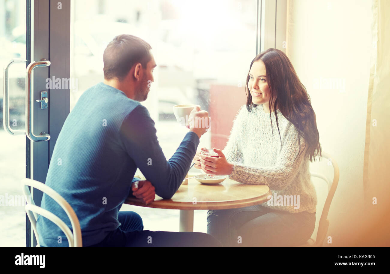happy couple drinking tea and coffee at cafe Stock Photo - Alamy