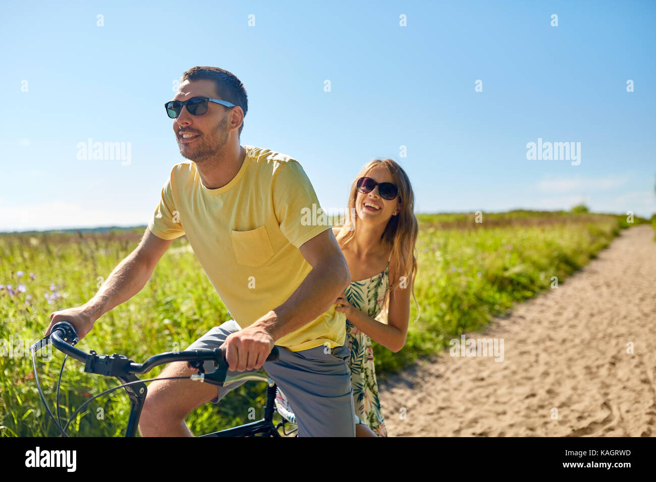 happy couple riding bicycle together in summer Stock Photo - Alamy