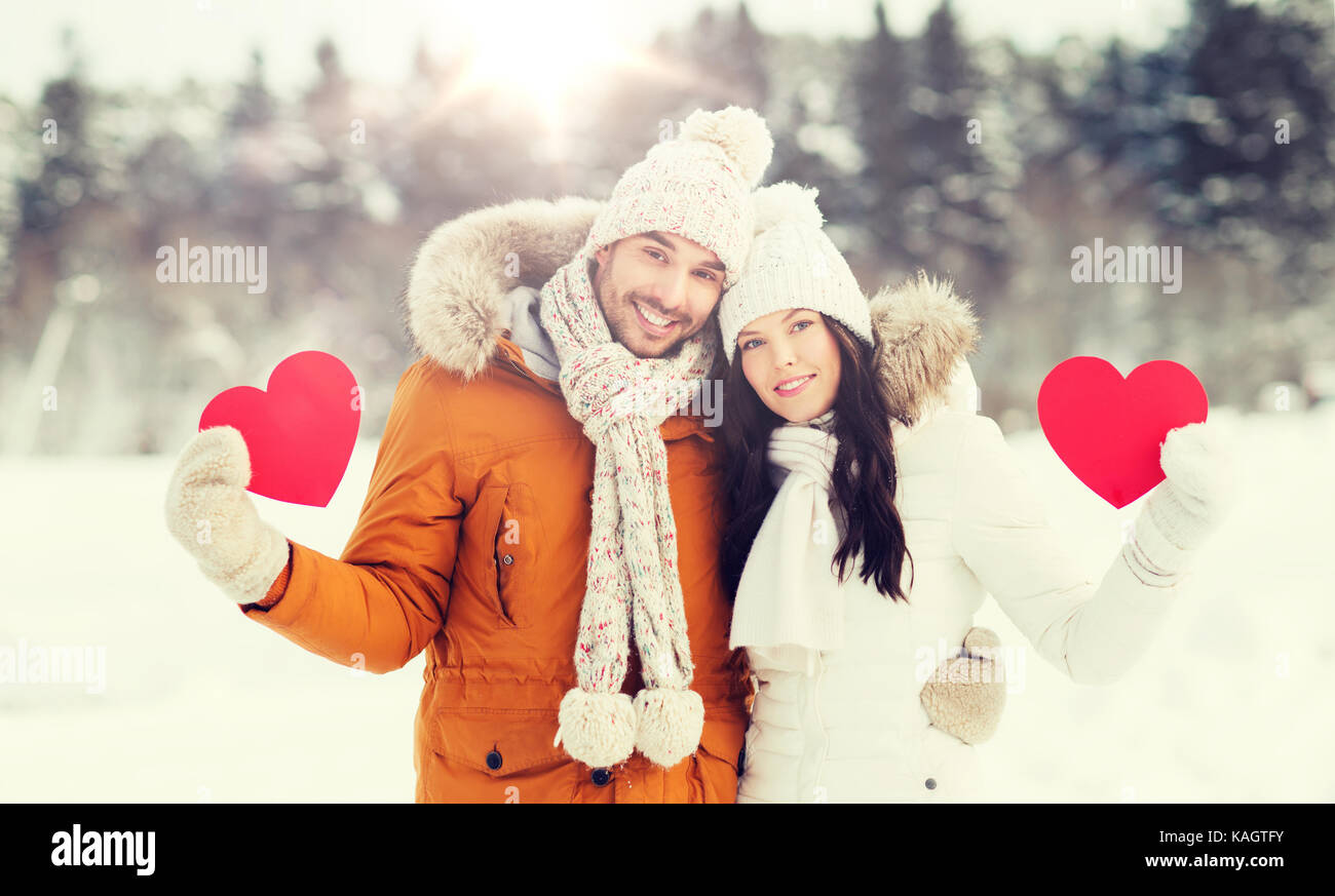 happy couple with red hearts over winter landscape Stock Photo - Alamy