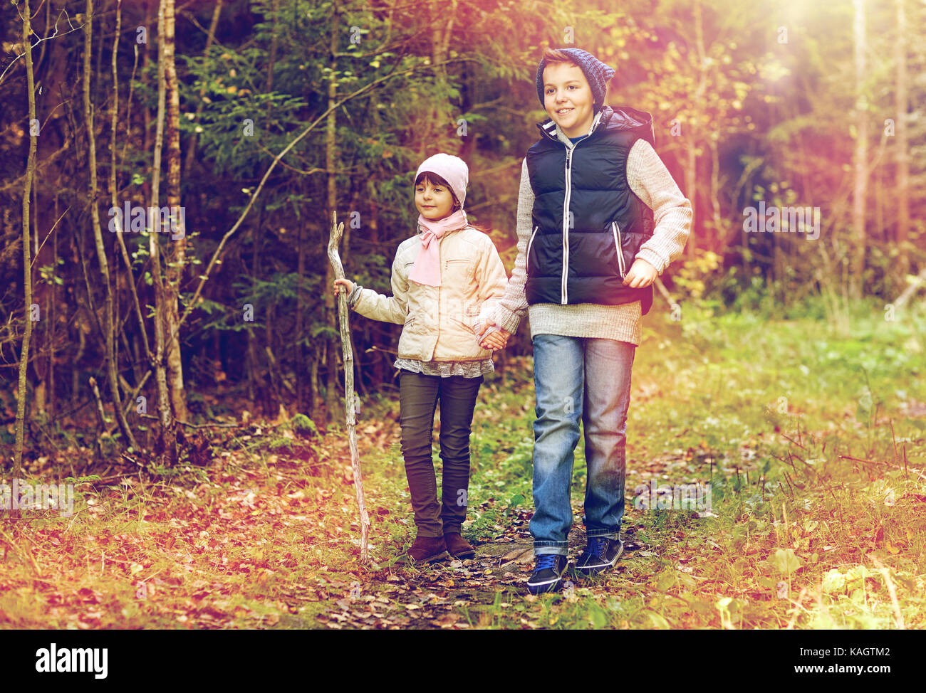 two happy kids walking along forest path Stock Photo - Alamy