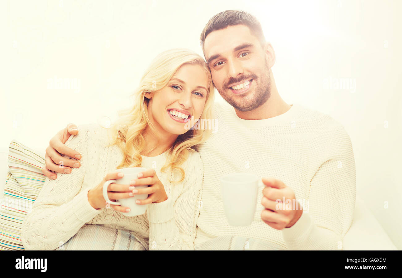 happy couple with cups drinking tea at home Stock Photo - Alamy