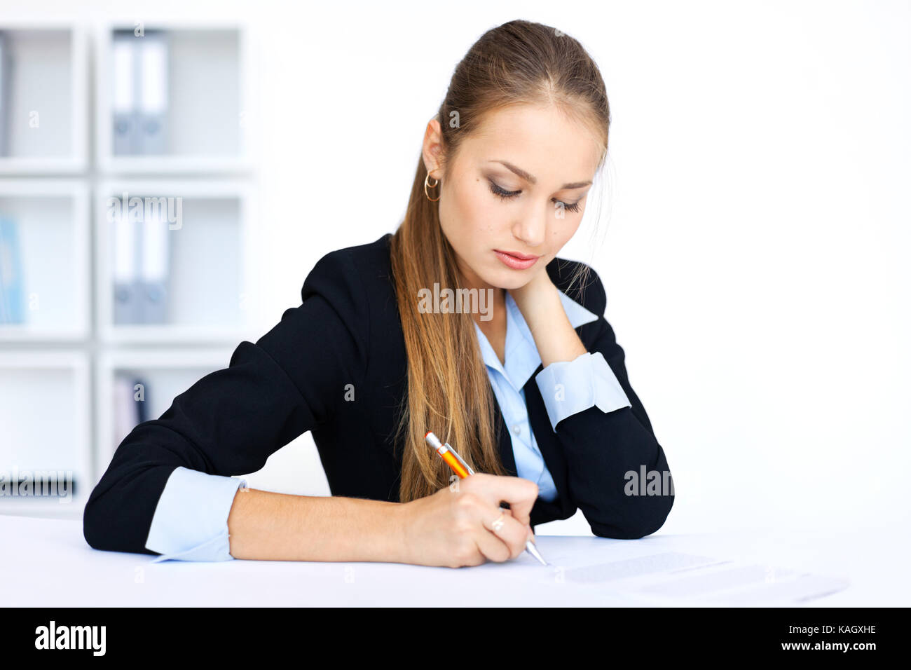 Portrait of a beautiful young business woman doing some paperwork in ...