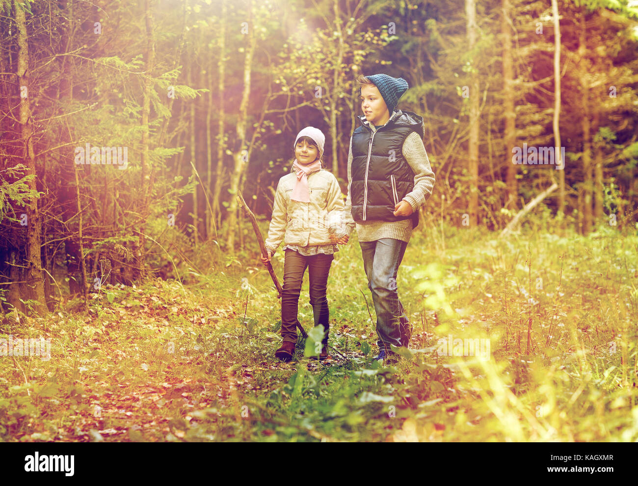 two happy kids walking along forest path Stock Photo - Alamy
