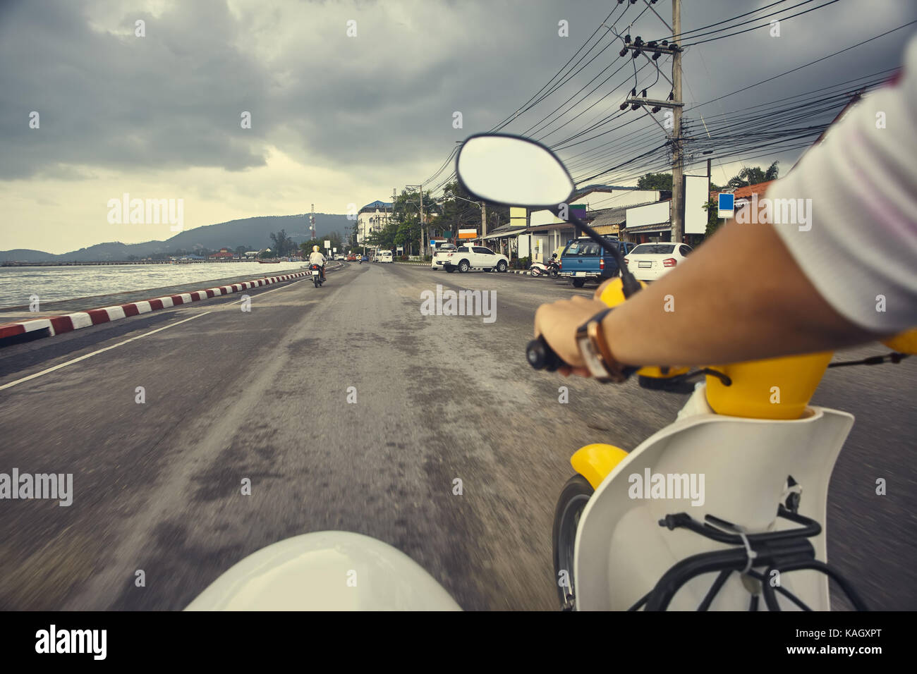 Driver riding motorcycle on an asphalt empty road near sea. Adventure ...