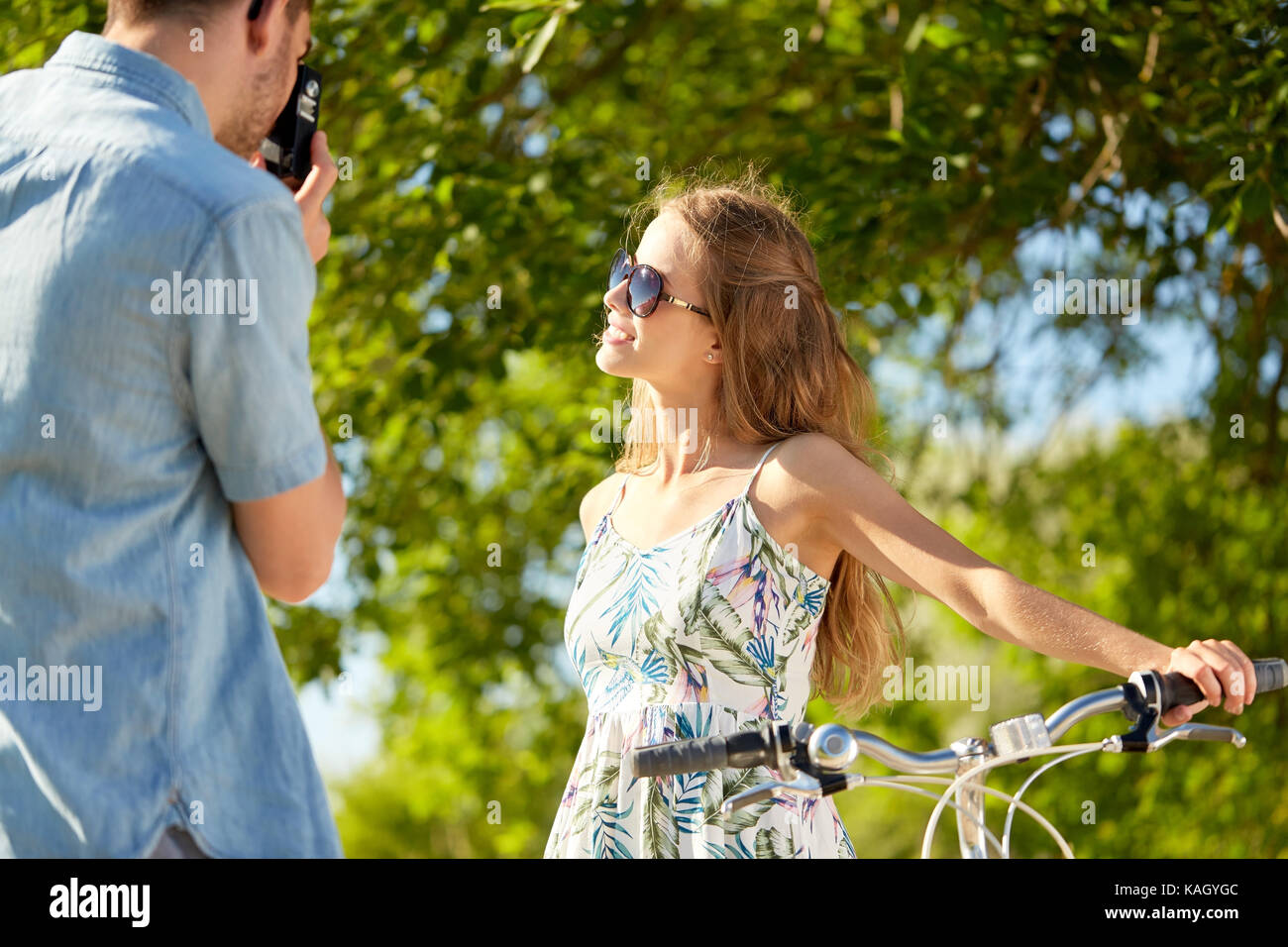 man photographing woman with bicycle by camera Stock Photo - Alamy