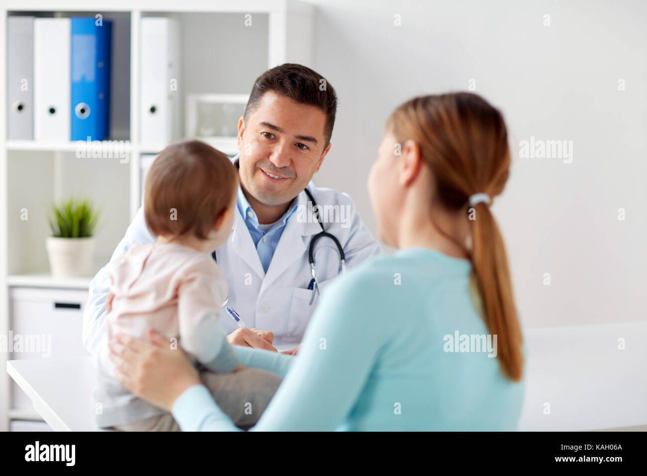 happy woman with baby and doctor at clinic Stock Photo - Alamy