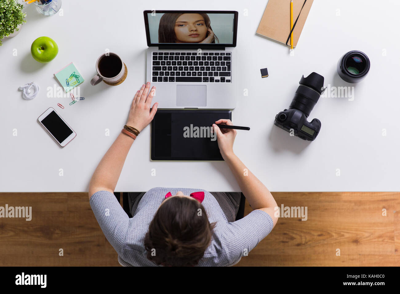 woman with camera working on laptop at table Stock Photo - Alamy