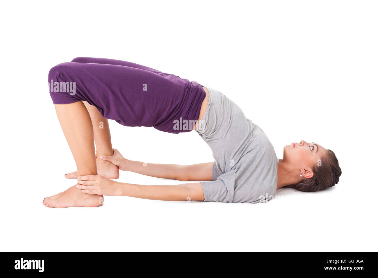 Young woman doing yoga exercise bridge pose. Isolated on white ...